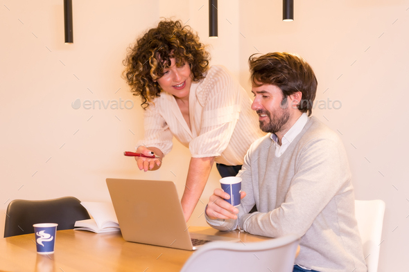 Female boss giving directions to worker at table in office Stock Photo ...