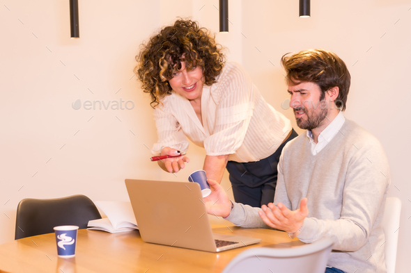 Female boss giving directions to worker at table in office Stock Photo ...