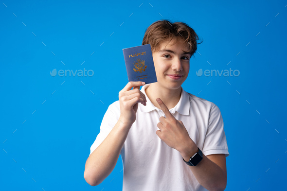 Portrait of glad handsome boy showing his passport going on vacation ...