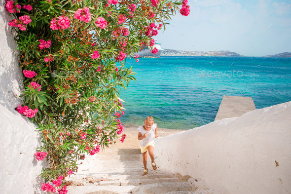 Adorable girl having fun outdoors. Kid at street of typical greek ...