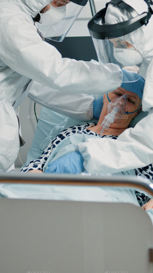 Medical team with protective uniforms using oxygen tube Stock Photo by ...