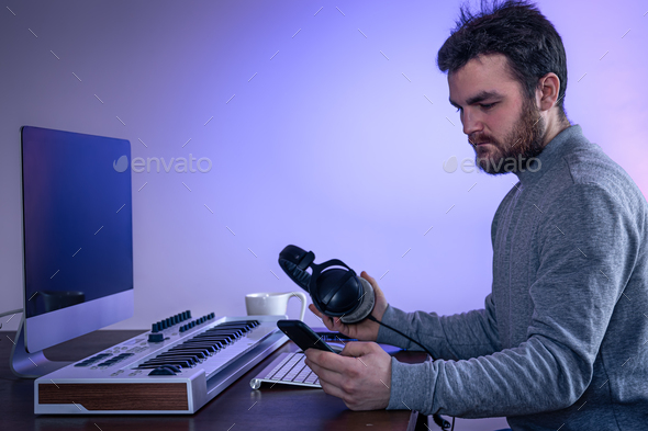 Male musician creates music using computer and keyboard, musician ...
