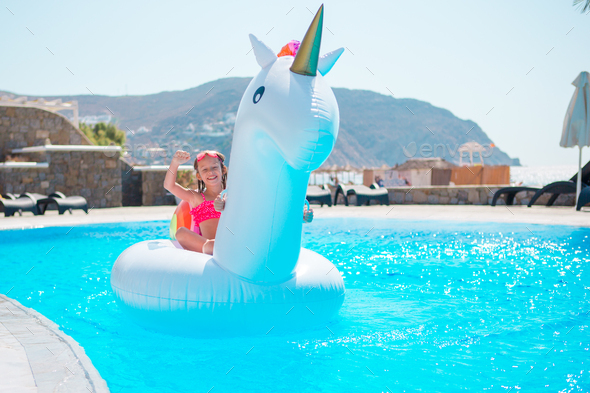 Adorable little girls at outdoor swimming pool having fun together ...