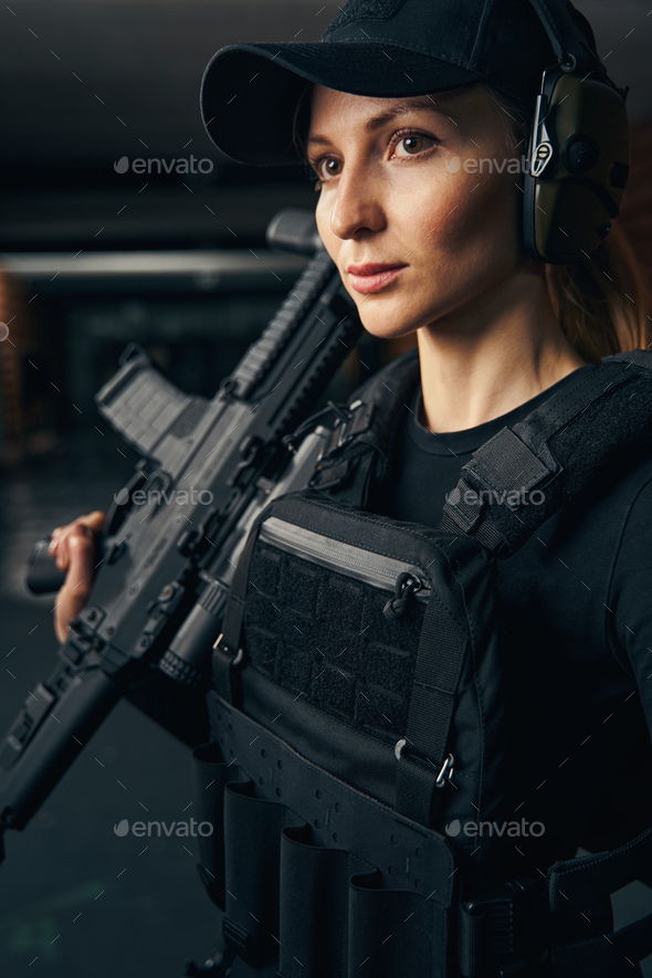 Beautiful female shooter with a firearm over her shoulder Stock Photo ...