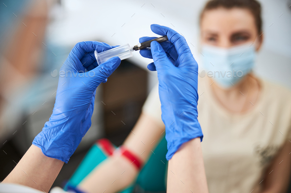 Phlebotomist assembling the syringe prior to blood collection Stock ...