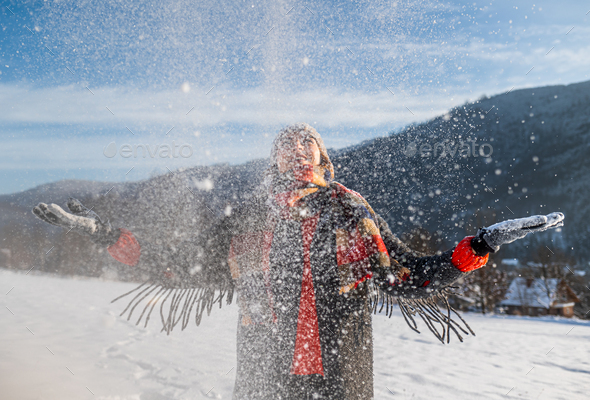 Winter madness woman throwing snow in the air Stock Photo by leszekglasner