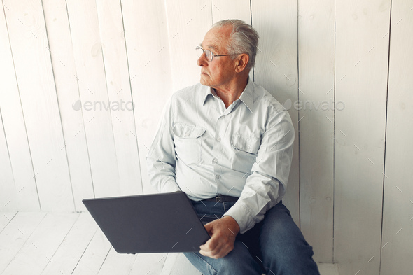 Elegant old man sitting at home and using a laptop Stock Photo by ...