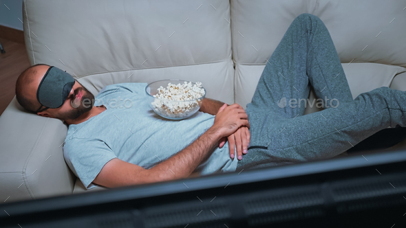 Caucasian male falling asleep while watching movie show sitting on ...
