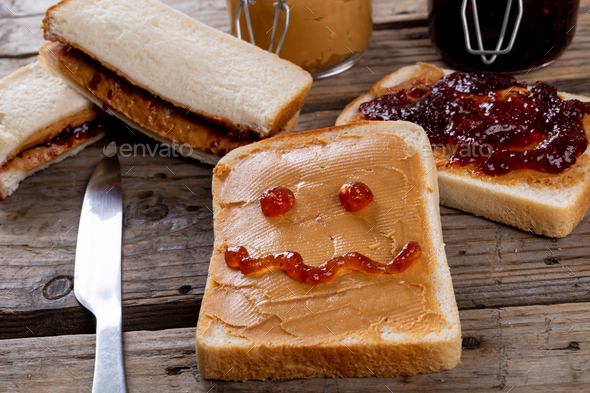 Anthropomorphic face on bread with peanut butter by table knife ...