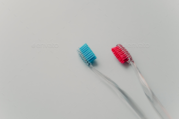 Realistic blue and red toothbrushes isolated on white wall with empty ...