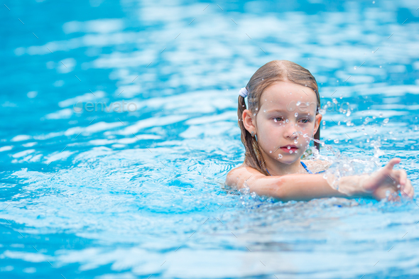 Adorable little girl having fun in outdoor swimming pool Stock Photo by ...