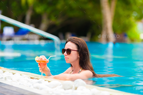 Beautiful young girl relaxing in the swimming pool Stock Photo by ...