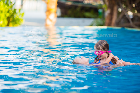 Adorable little girls in outdoor swimming pool on vacation Stock Photo ...