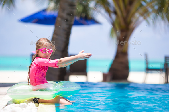 Smiling adorable girl having fun in outdoor swimming pool Stock Photo ...