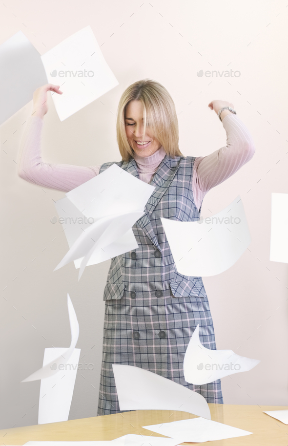 business woman throwing paper into he air and smiling. end of the day ...
