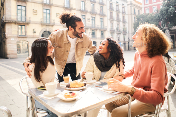 Group of friends meet in the street. People having breakfast outdoors ...
