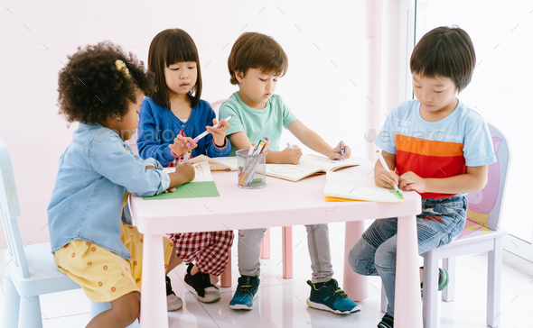 Group of diversity kid sitting together around the table in classroom ...