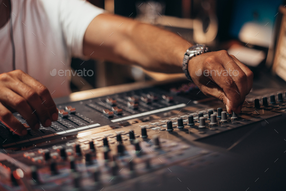 Senior hispanic music producer working on a mixing soundboard while in ...