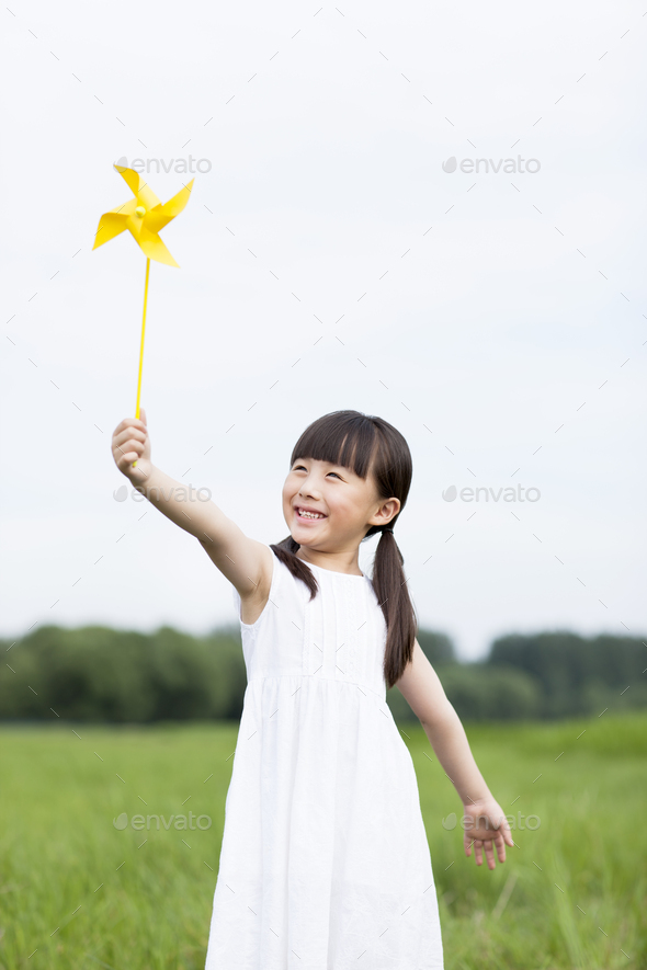 Happy girl playing paper windmill in the open air Stock Photo by ...