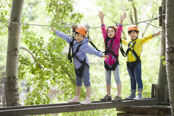 Happy children playing in tree top adventure park Stock Photo by ...