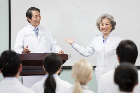 Medical workers giving speech in boardroom Stock Photo by bluejeanimages