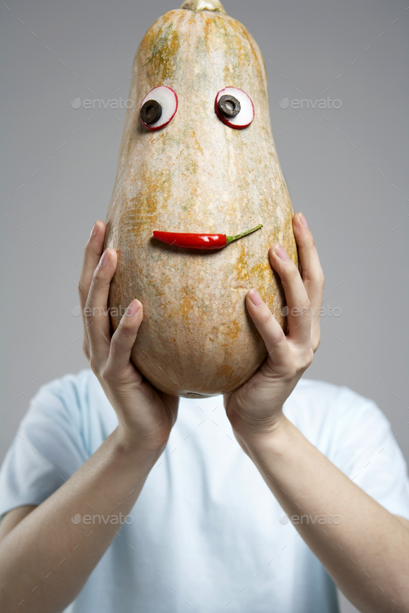Male Covering Face With Vegetable Mask Stock Photo by bluejeanimages