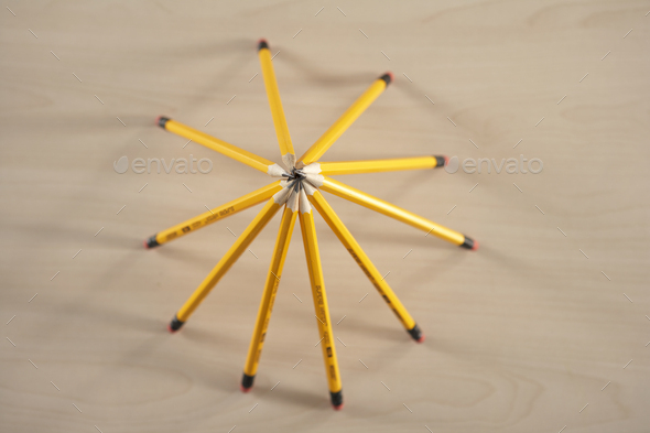 Pencils propped up in a pyramid shape Stock Photo by bluejeanimages