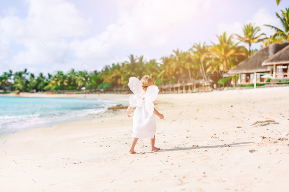 Beautiful young girl wearing angel wings on the beach Stock Photo by ...