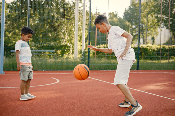 Two brothers playing basketball in basketball court together Stock ...