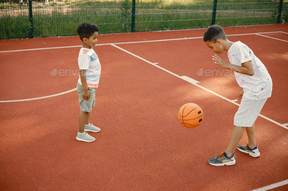 Two brothers playing basketball in basketball court together Stock ...