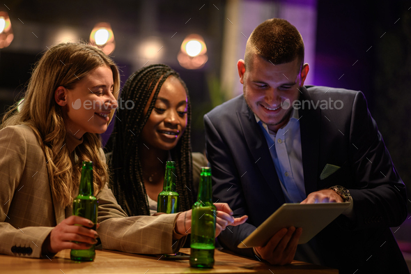 Cheerful colleagues drinking beer in the bar together after work Stock ...