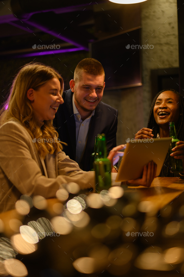 Cheerful colleagues drinking beer in the bar together after work Stock ...