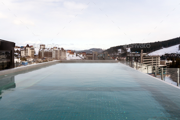 Snow falling on pool at the winter mountains. Winter resort with ...