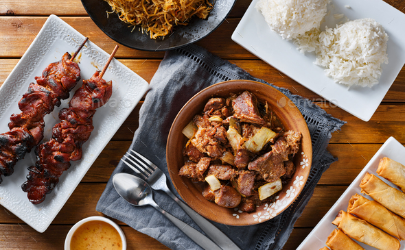pork adobo meal with filipino foods such as lumpia, pancit noodles, and ...