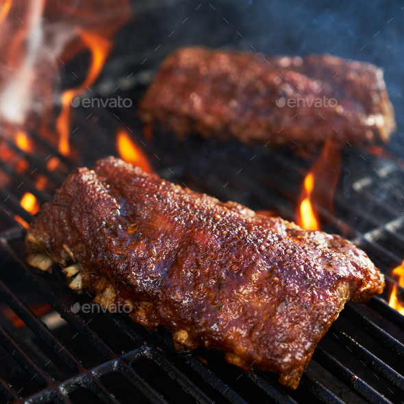 bbq pork ribs cooking on flaming grill Stock Photo by joshua_resnick