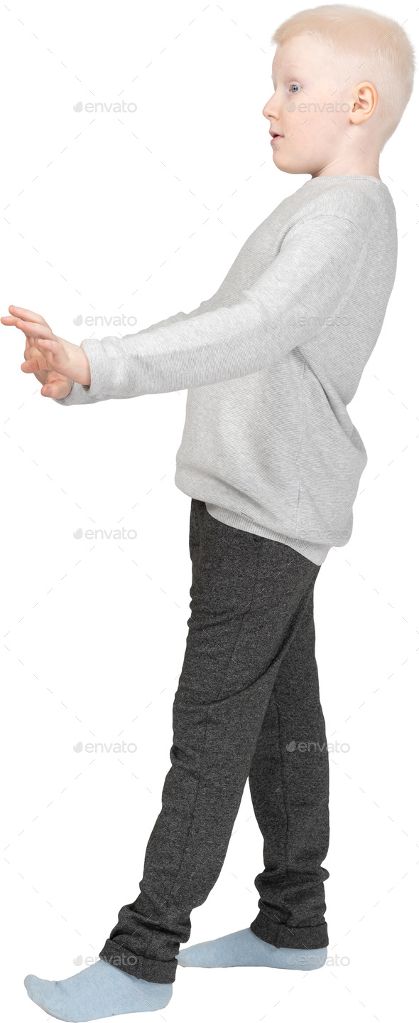 a young boy standing with his arm outstretched and pointing Stock Photo ...