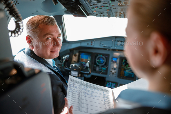 Aircraft pilot talking with stewardess in cockpit Stock Photo by ...