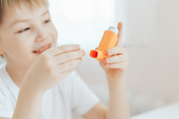 Boy opened the lid and examines the inhaler Stock Photo by Nestea06