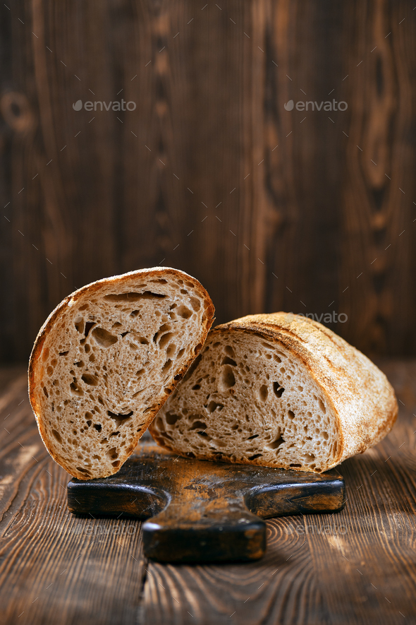 Loaf of artisan sourdough bread with porous texture cut on half. Stock ...