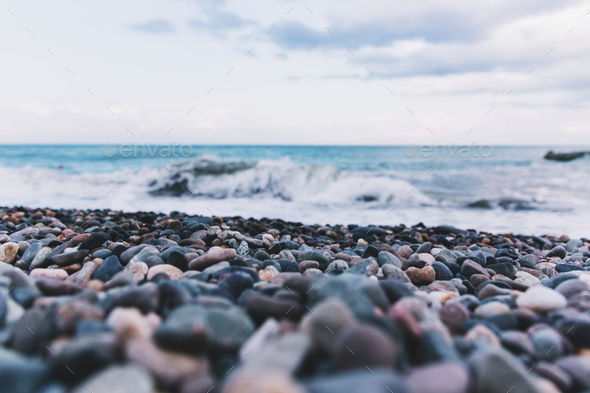 Seascape. Blue and gray pebbles on the beach. White sea waves.Skyline ...