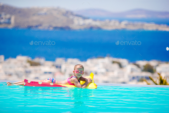 Adorable little girl playing in outdoor swimming pool with beautiful ...