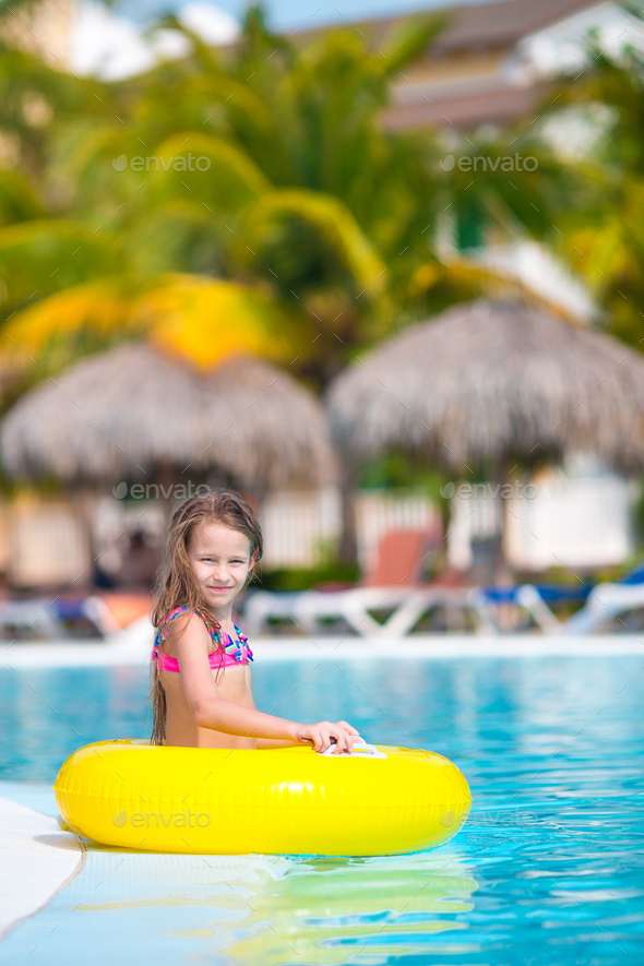 Little girl with inflatable rubber circle in swimming pool Stock Photo ...