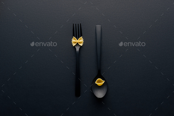 top view of spoon upside down with shell macaroni and fork with ...