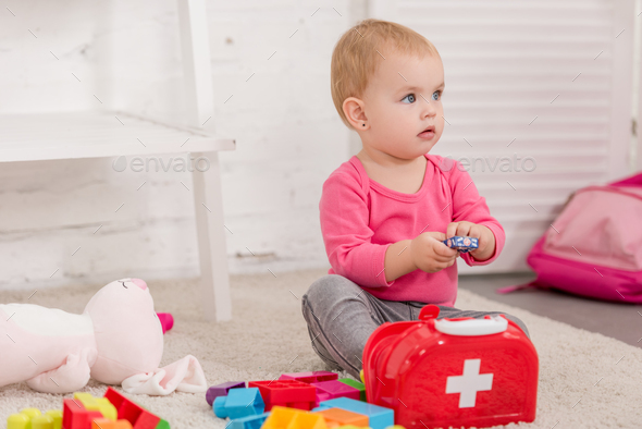 adorable child playing with first aid kit in children room Stock Photo ...