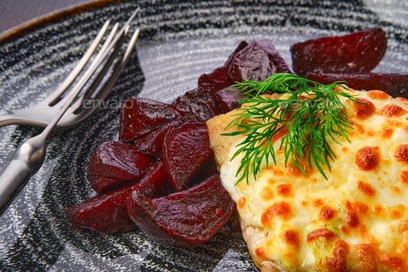 Fried cod fillet with melted cheese topping and roasted beetroot slices ...