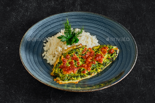 Fried fillet of white fish with spinach and cheese topping and served ...