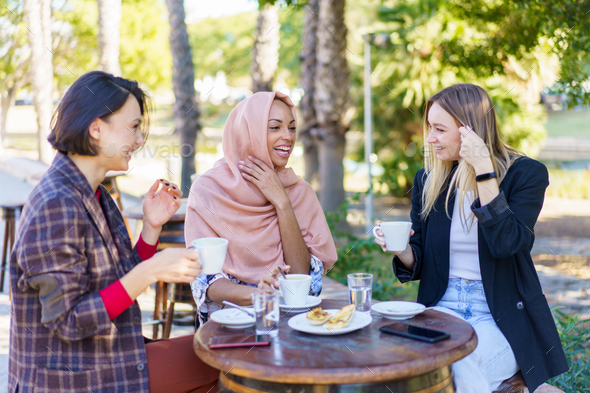 Cheerful multiracial women having coffee break Stock Photo by javi_indy