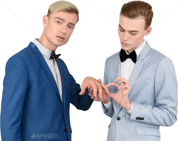 two men in suits looking at each other while one of them is fixing the ...