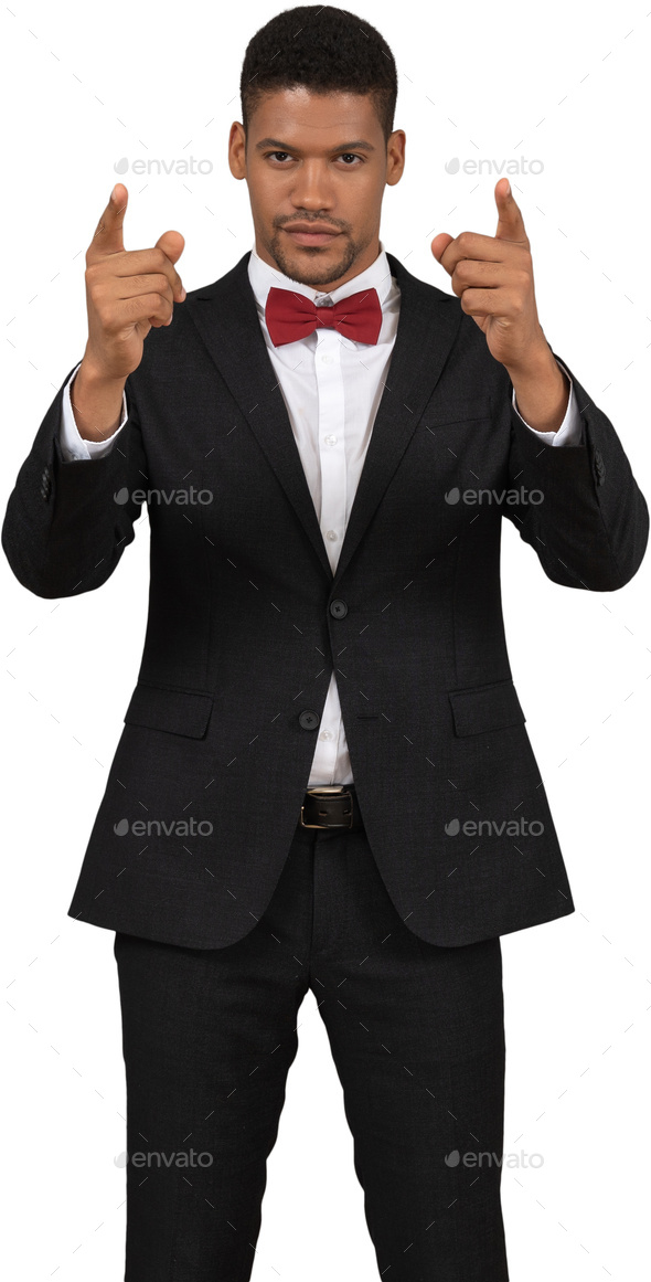 a man in a black suit and red bow tie holding his hands up with his ...