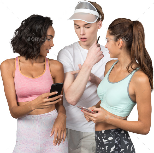three people standing together looking at a cell phone Stock Photo by ...